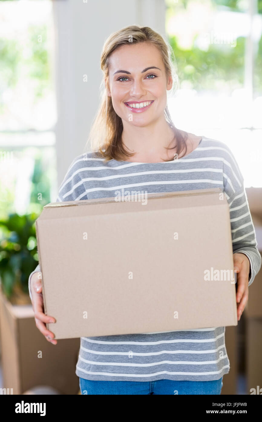Portrait of young woman holding cardboard boxes Stock Photo - Alamy
