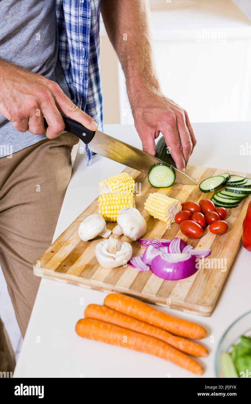 Mid-section of man chopping vegetable in kitchen Stock Photo - Alamy