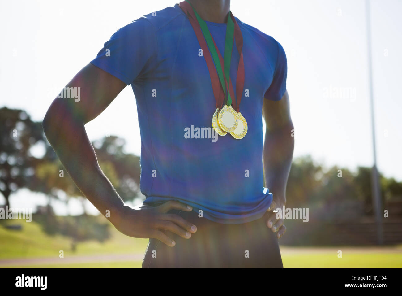 Mid section of athlete posing with gold medal after victory Stock Photo ...