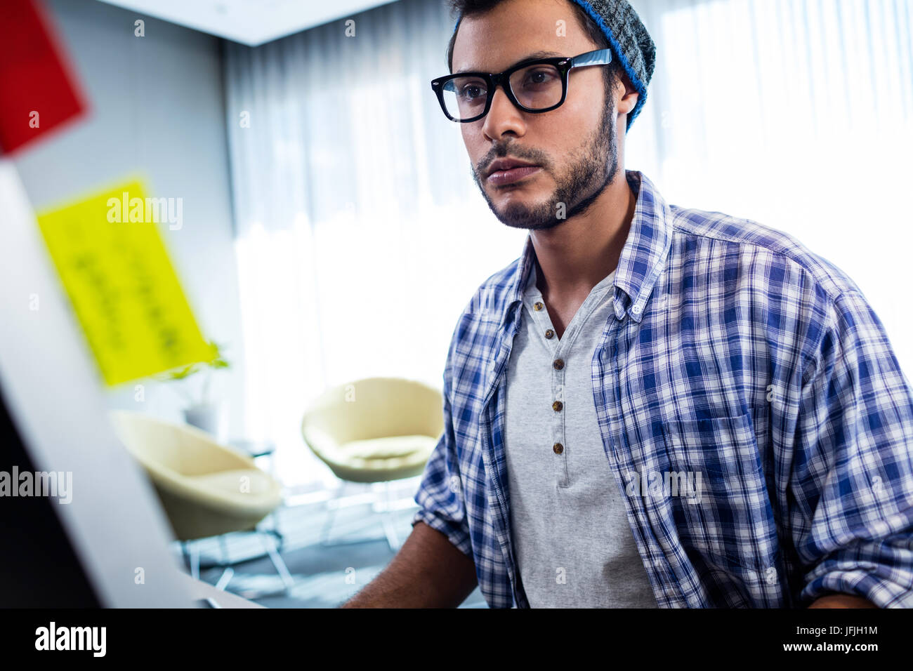 Focus on hipster man working at computer desk Stock Photo - Alamy