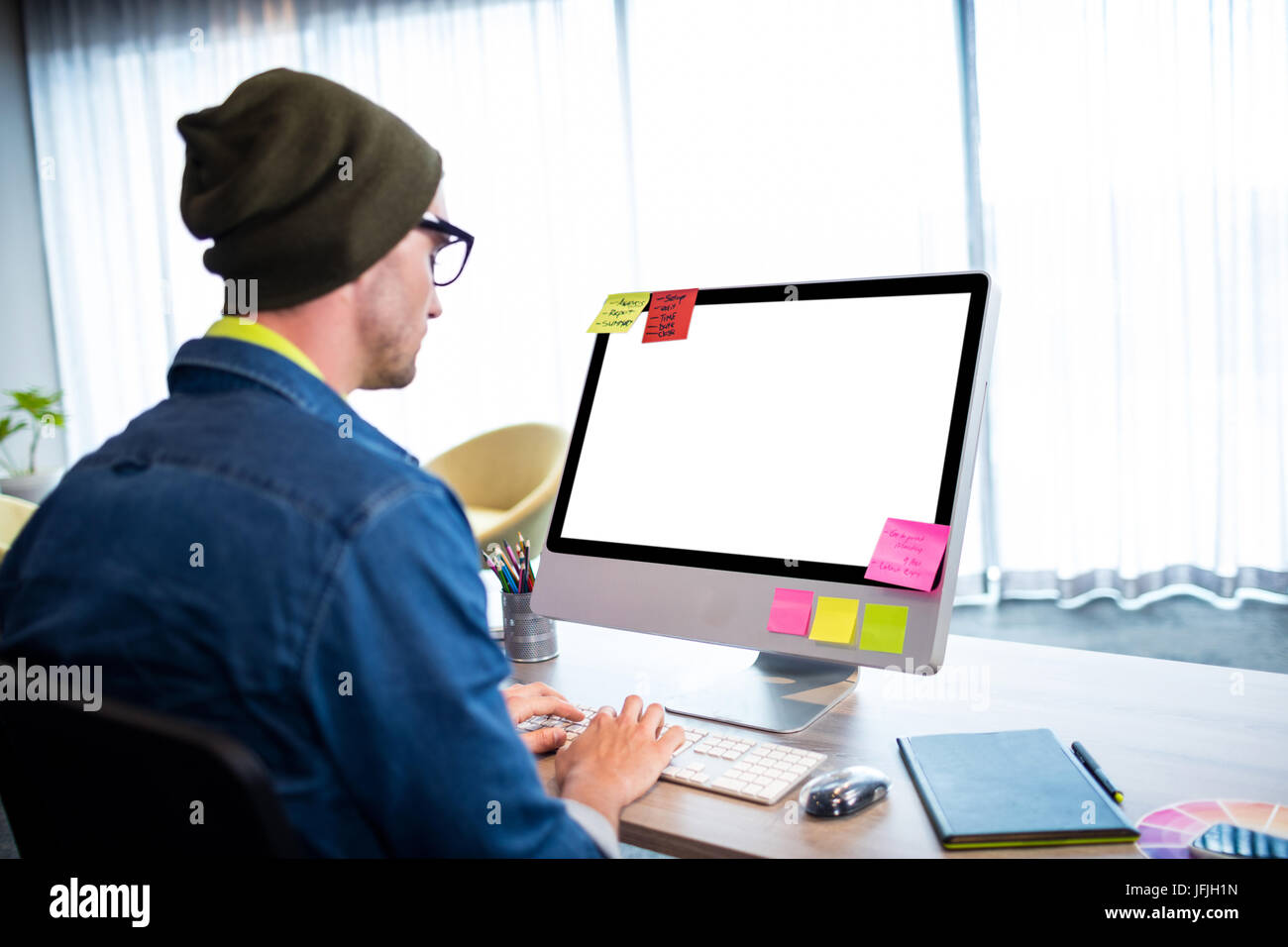 Side view of casual man working at computer desk Stock Photo - Alamy