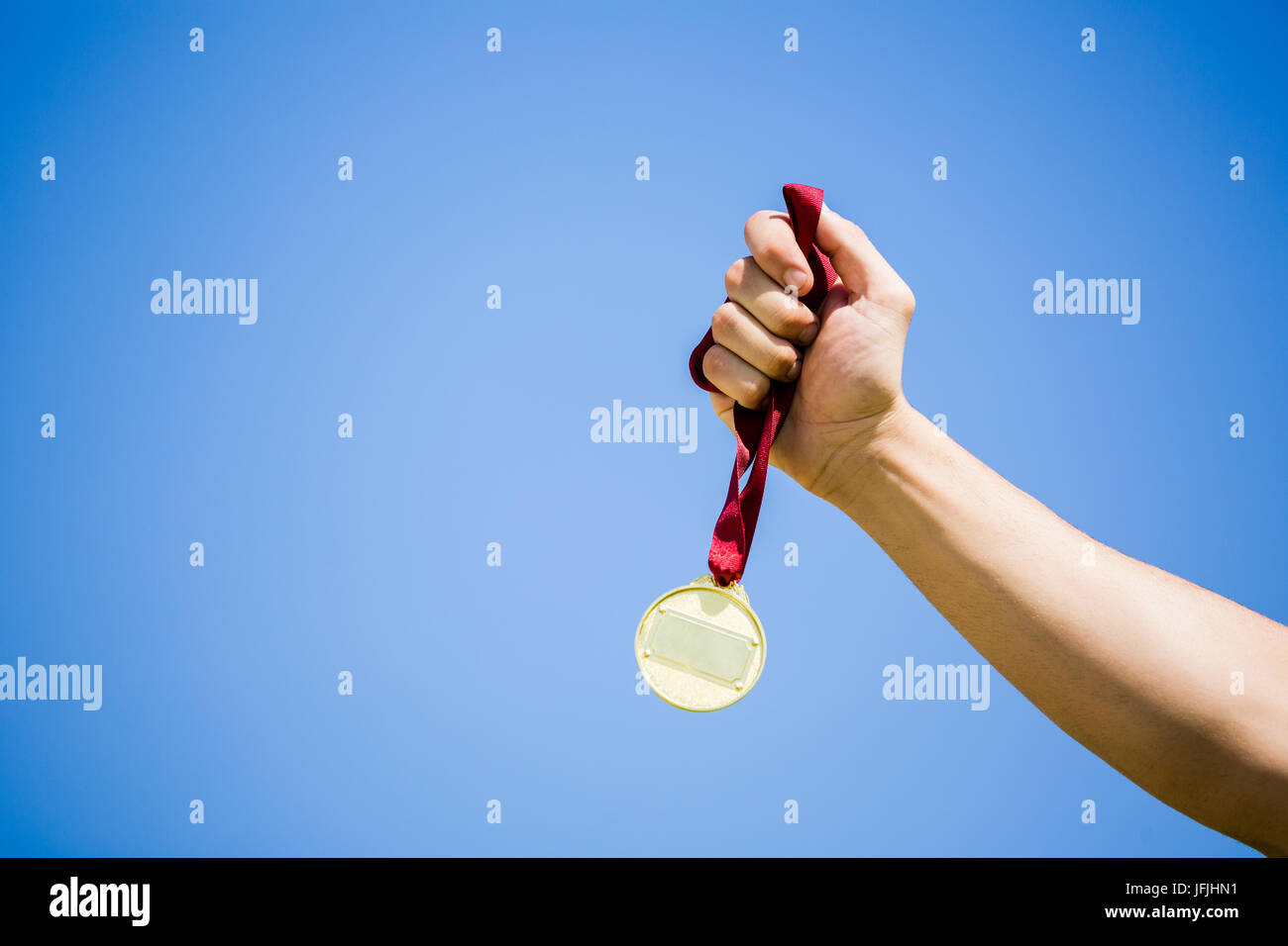 Athlete hand holding gold medal after victory Stock Photo - Alamy