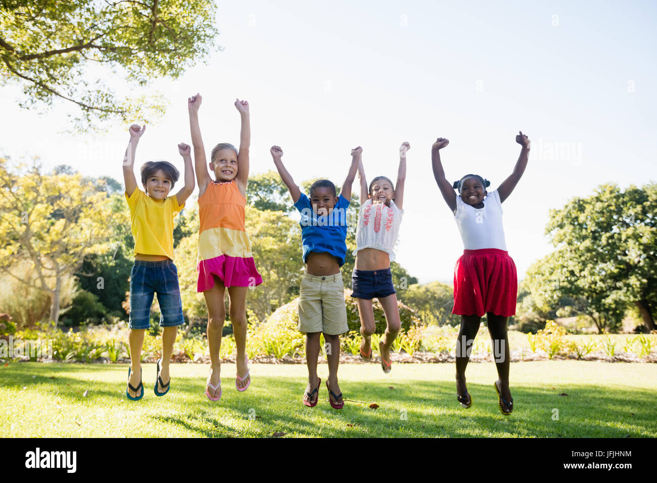 Happy kids jumping together during a sunny day Stock Photo - Alamy