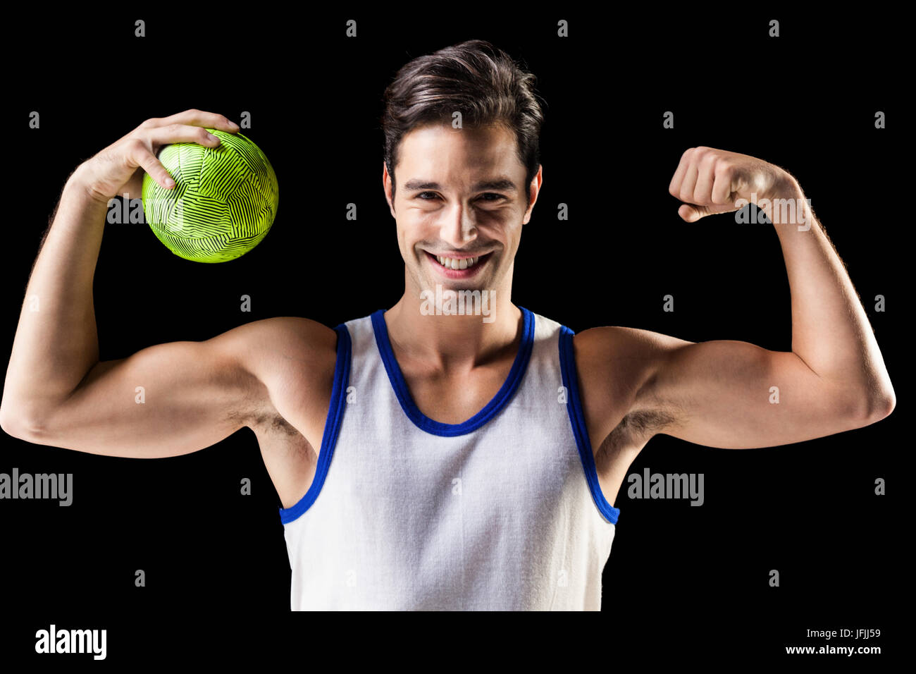 Portrait of happy athlete man holding ball and showing muscles Stock ...