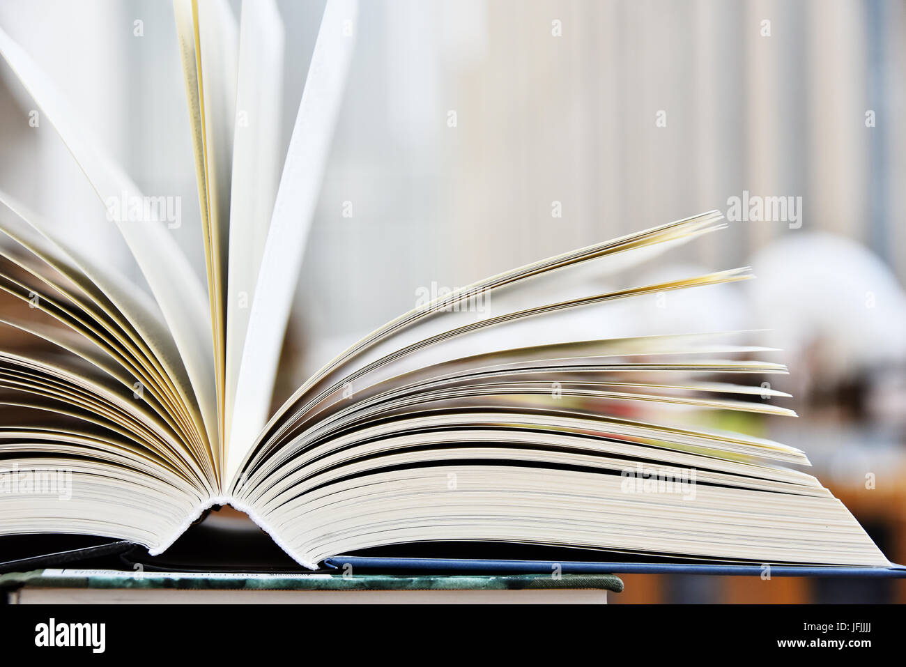 Hardcover book lying on the table in a library Stock Photo - Alamy