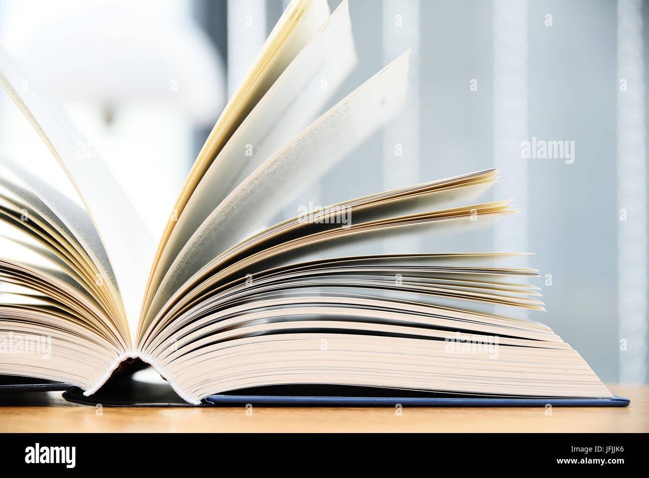 Hardcover book lying on the table in a library Stock Photo - Alamy