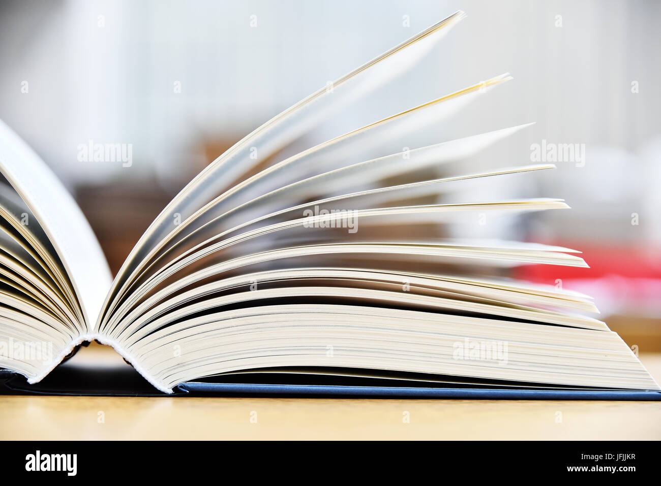Hardcover book lying on the table in a library Stock Photo - Alamy