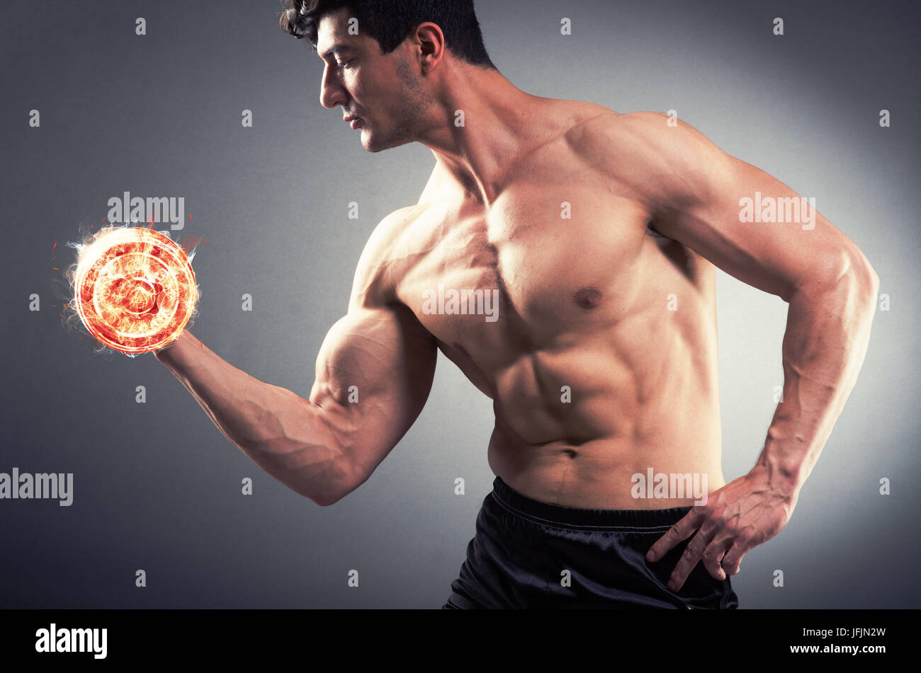Muscular ripped bodybuilder with burning dumbbells Stock Photo - Alamy