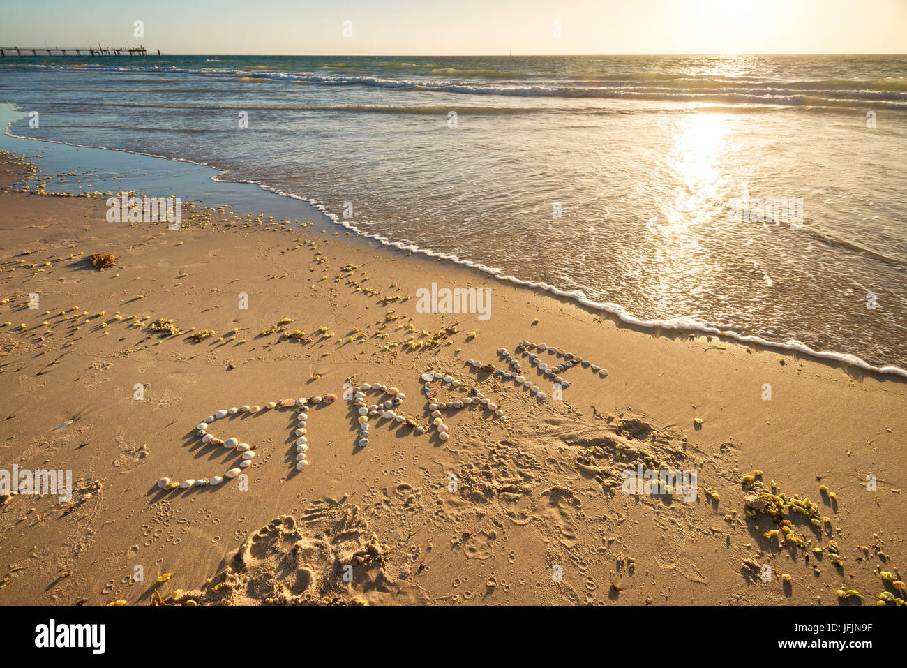 Straya text drawn using shells on sand. Straya is an abbreviation of ...