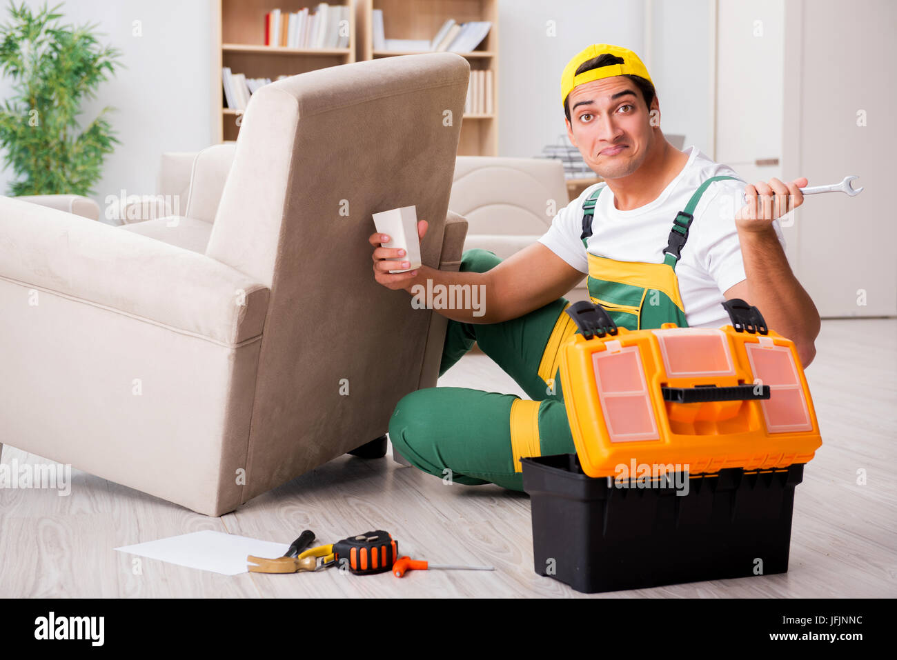 Furniture repairman repairing armchair at home Stock Photo - Alamy
