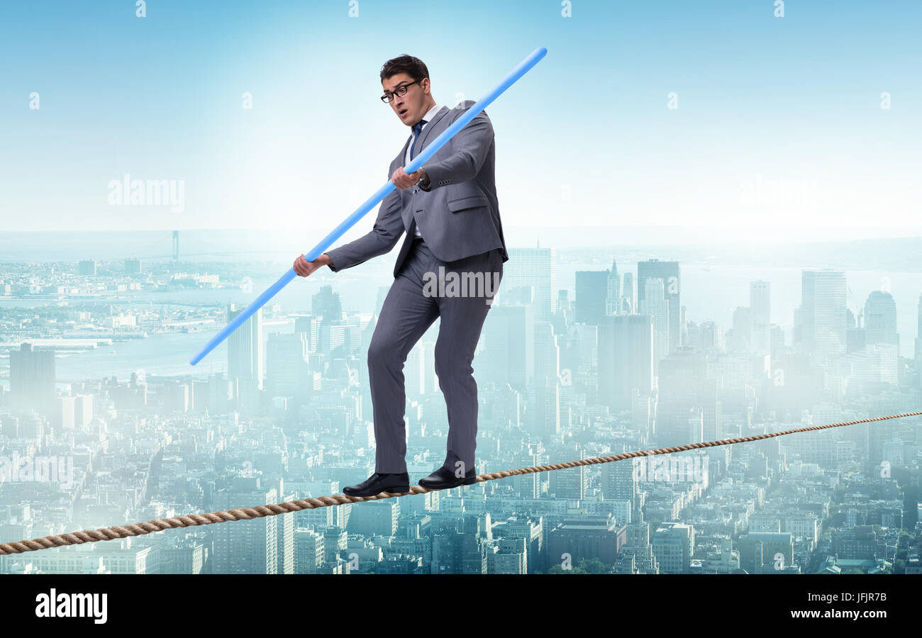 Businessman doing tightrope walking in risk concept Stock Photo - Alamy
