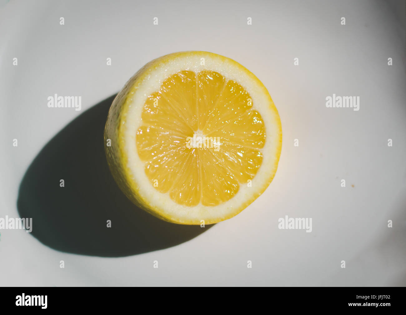 A lemon cut in half on a white surface Stock Photo - Alamy
