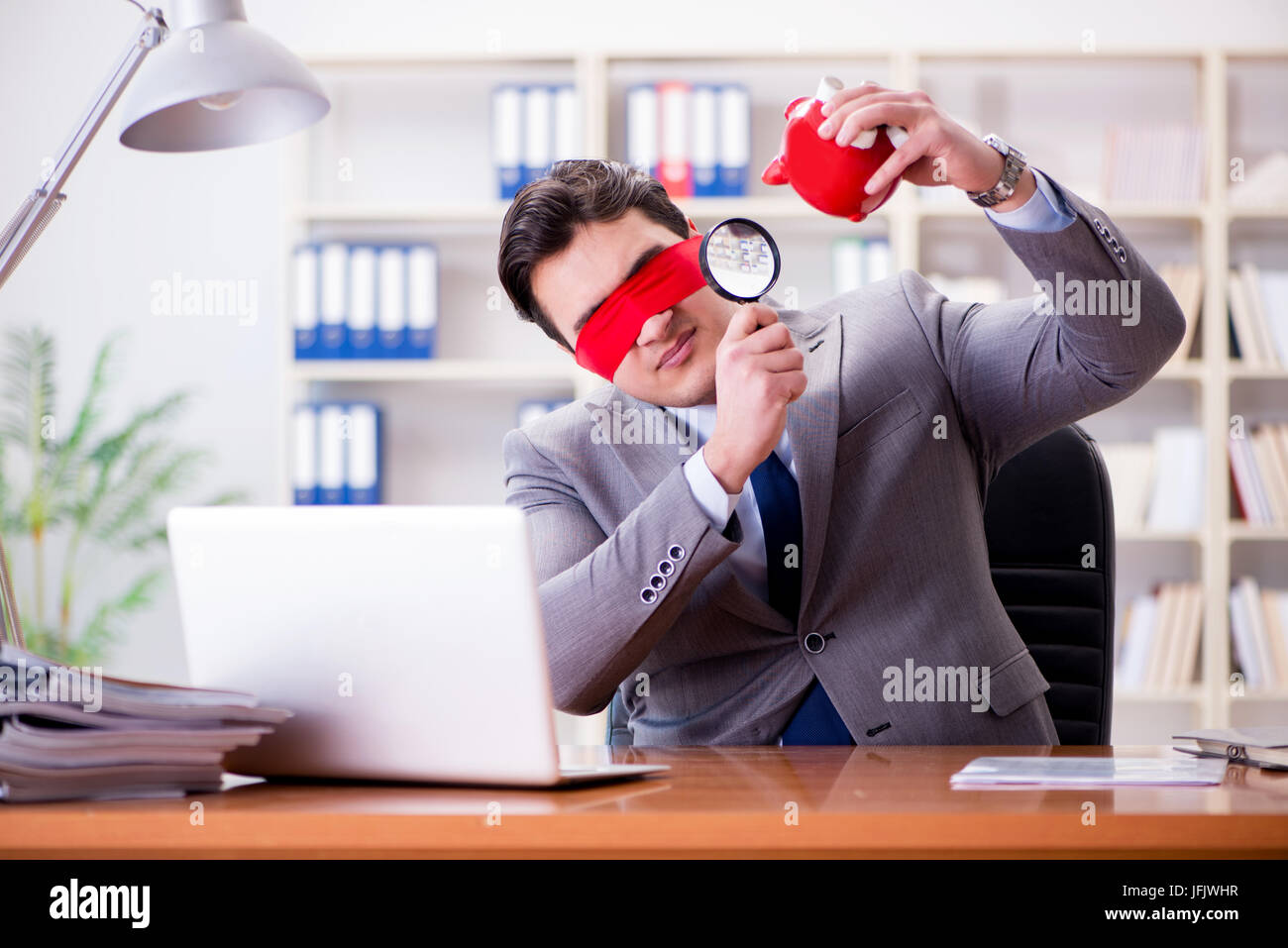 Blindfold businessman sitting at desk in office Stock Photo - Alamy