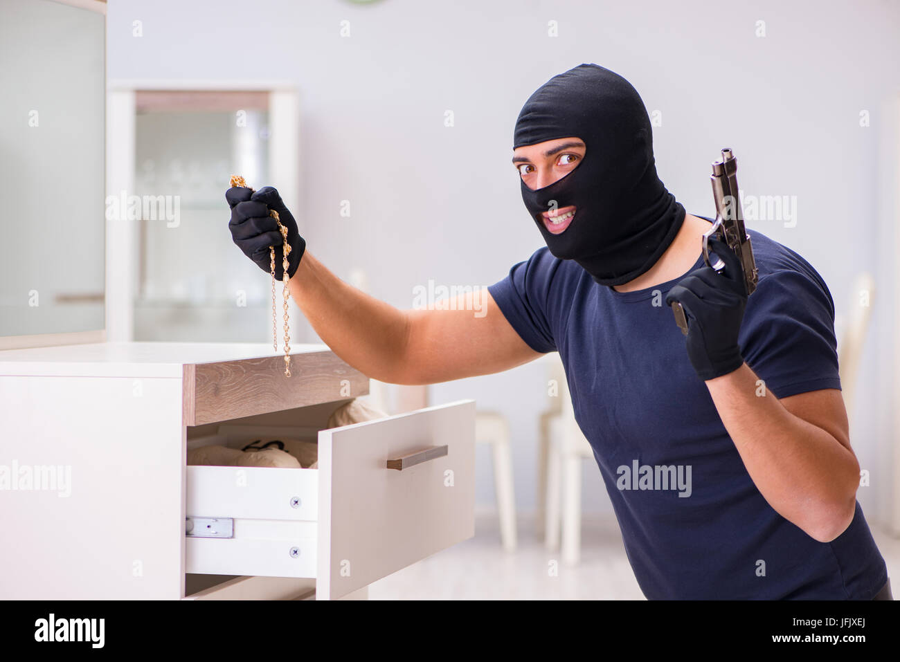 Robber wearing balaclava stealing valuable things Stock Photo - Alamy