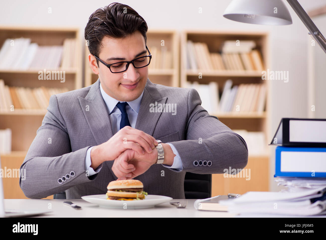 Hungry funny businessman eating junk food sandwich Stock Photo - Alamy