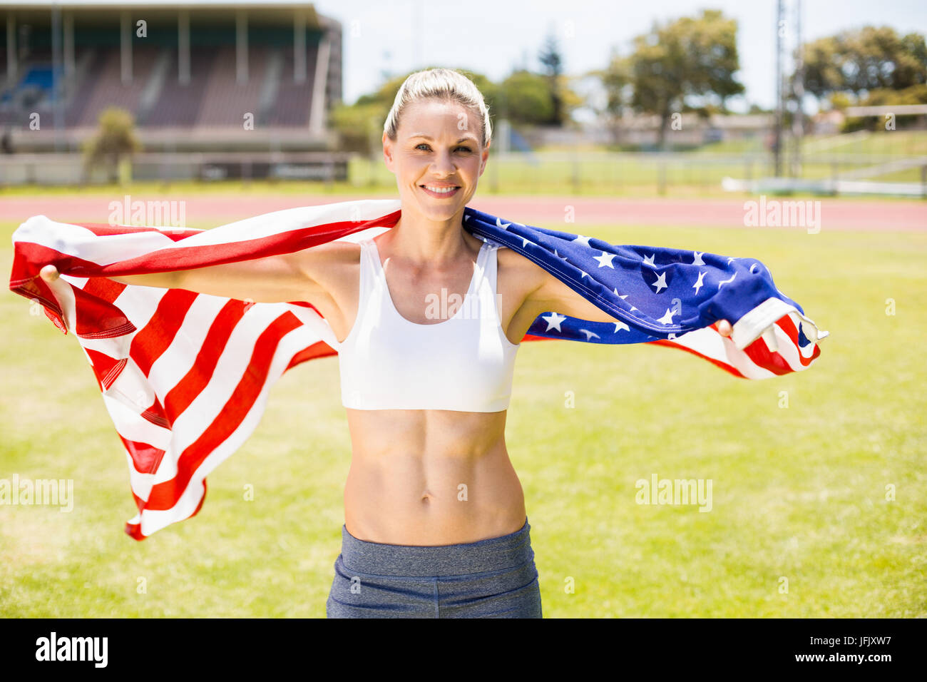 Portrait of female athlete wrapped in american flag Stock Photo - Alamy