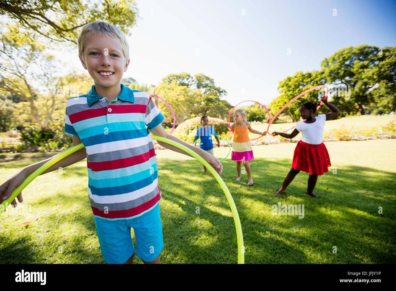 Kids playing hoop together during a sunny day Stock Photo - Alamy