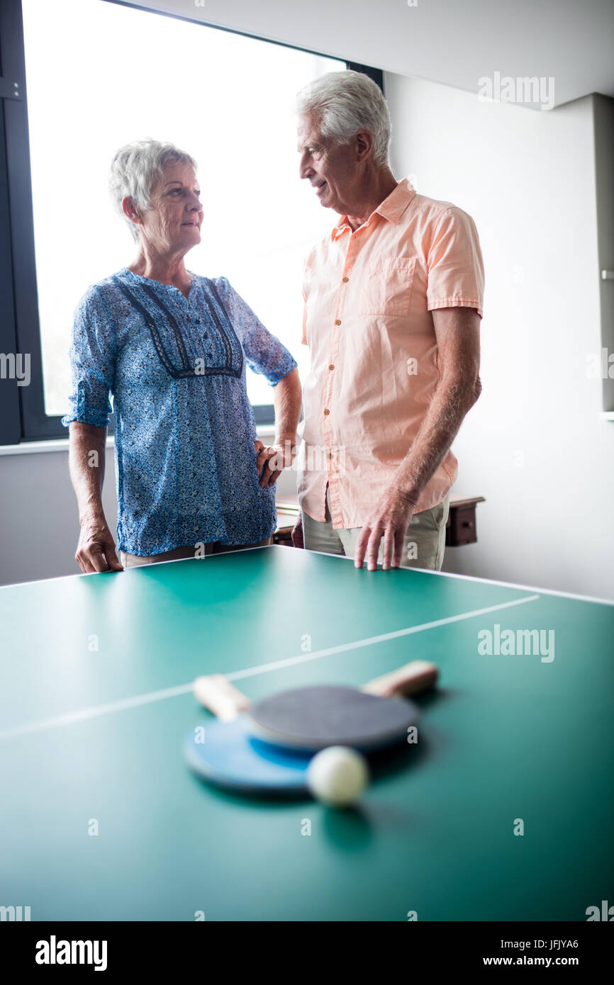 Couple of seniors interacting behind a ping pong table Stock Photo - Alamy