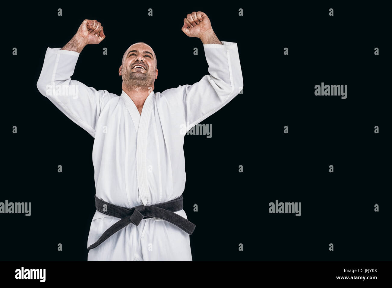 Composite image of fighter posing after victory Stock Photo - Alamy