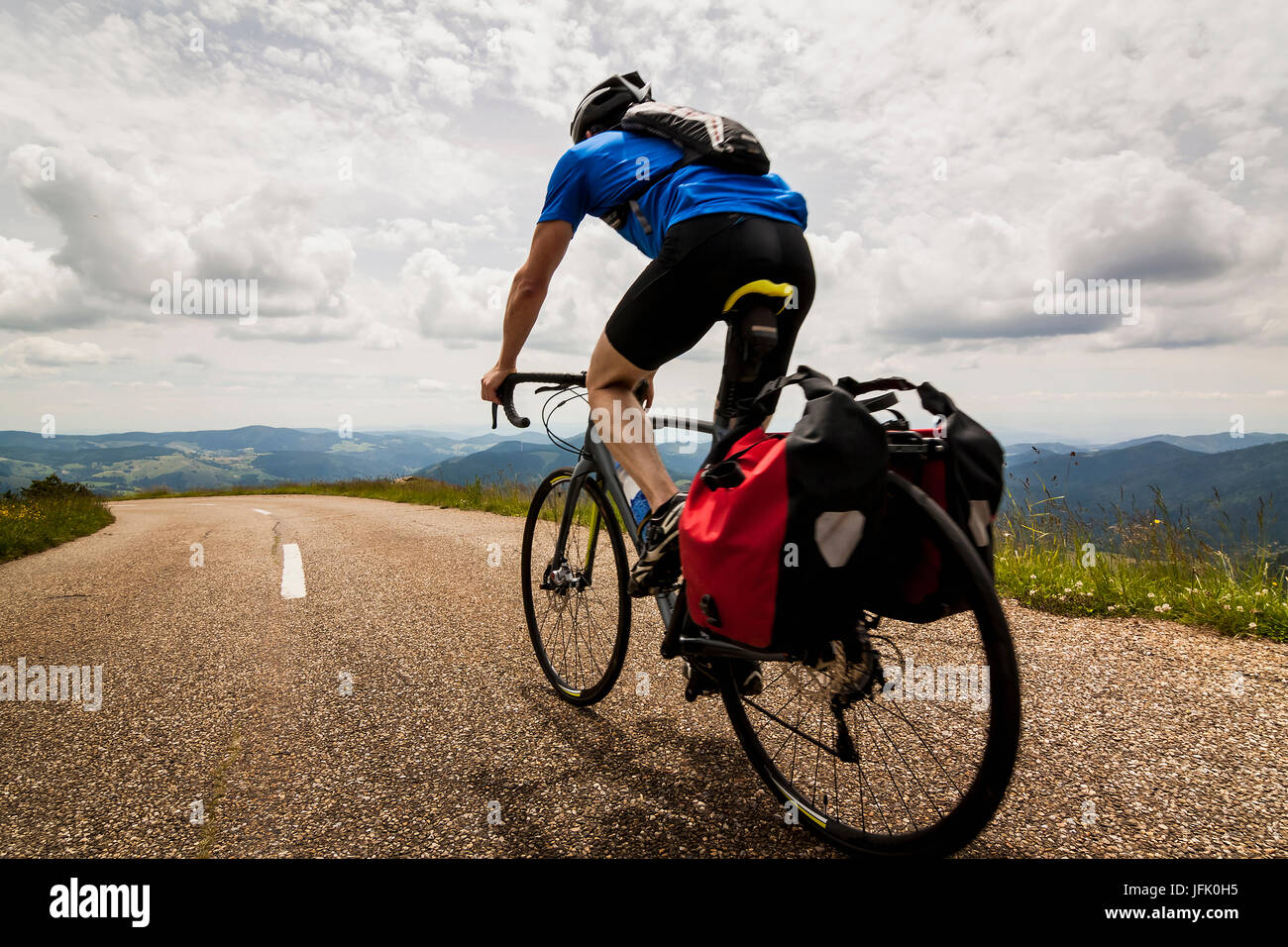 Rear view of man riding bicycle on road Stock Photo - Alamy