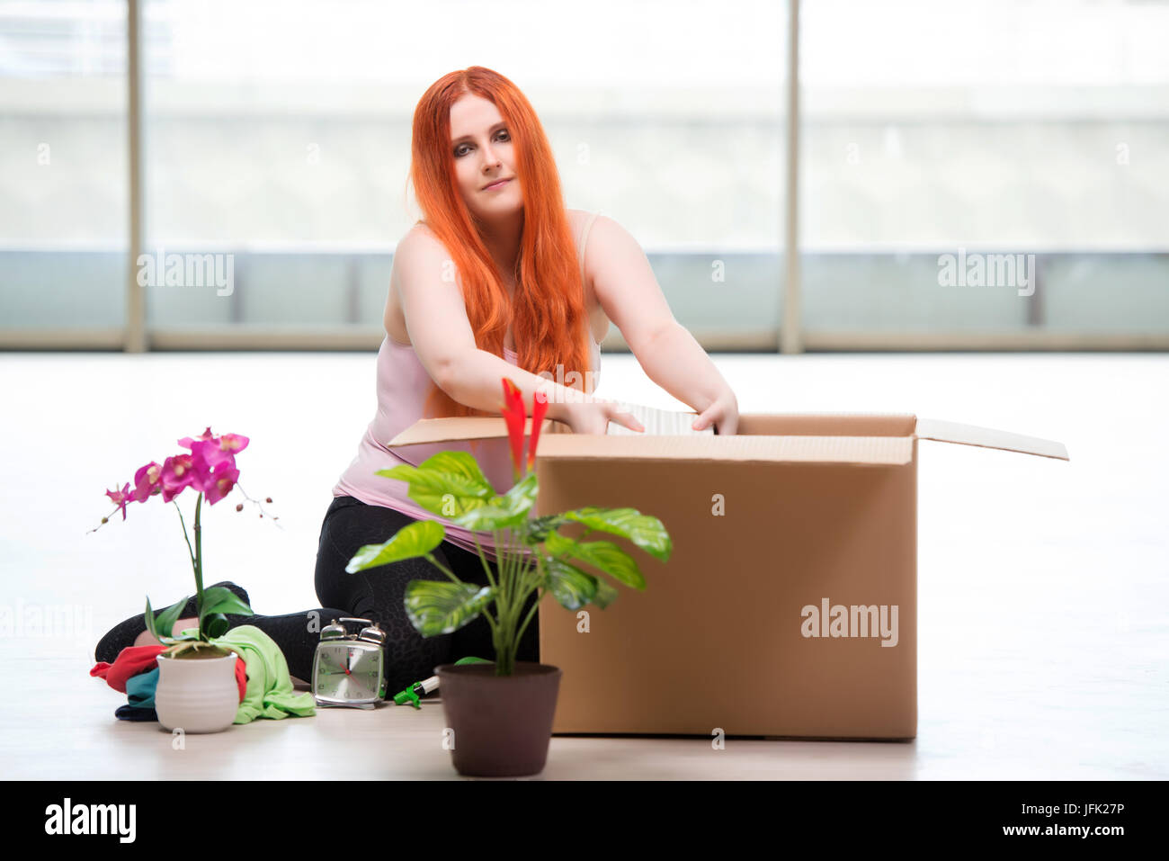 Young woman moving house in lifestyle concept Stock Photo - Alamy