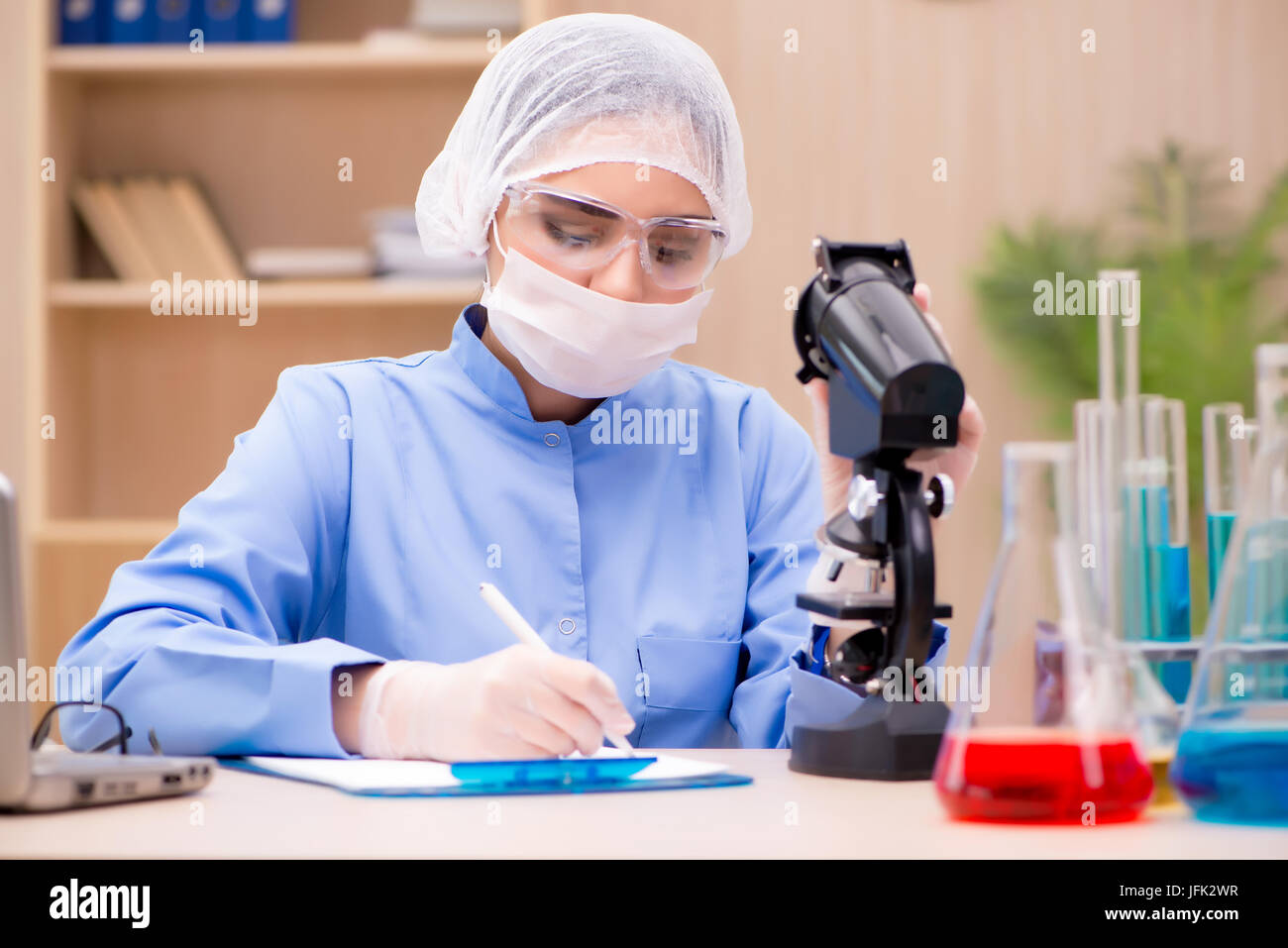 Lab chemist working with microscope and tubes Stock Photo - Alamy