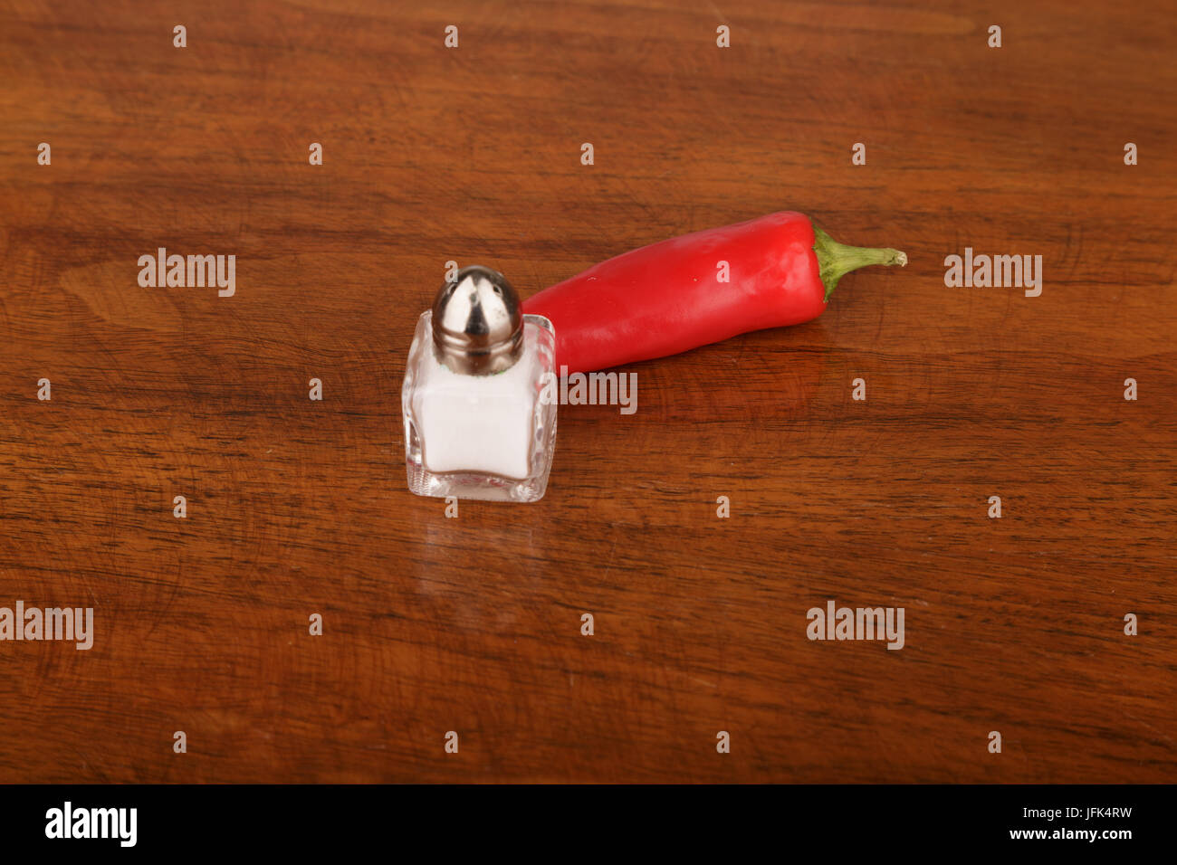 White Salt and Red Pepper on Wood Table Stock Photo - Alamy