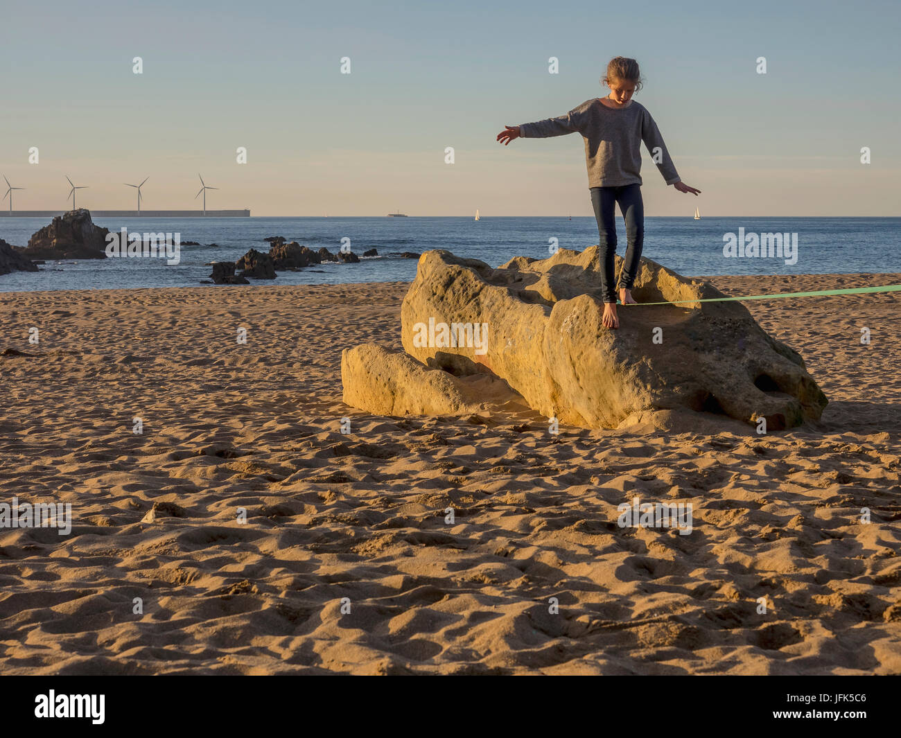 Girl balancing along a slackline on a beach in Northern Spain Stock ...
