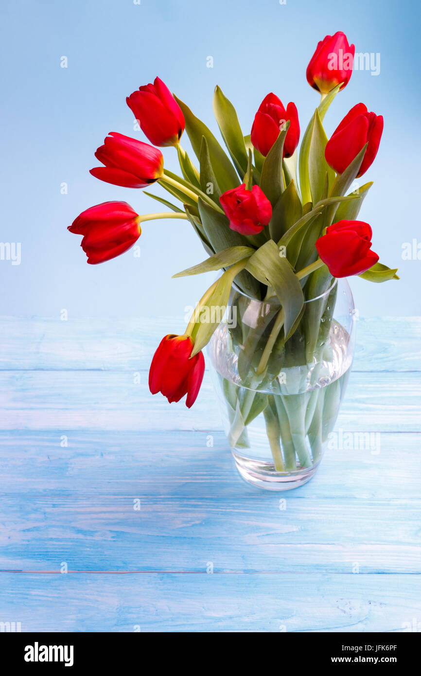 Red tulips on wooden table Stock Photo - Alamy