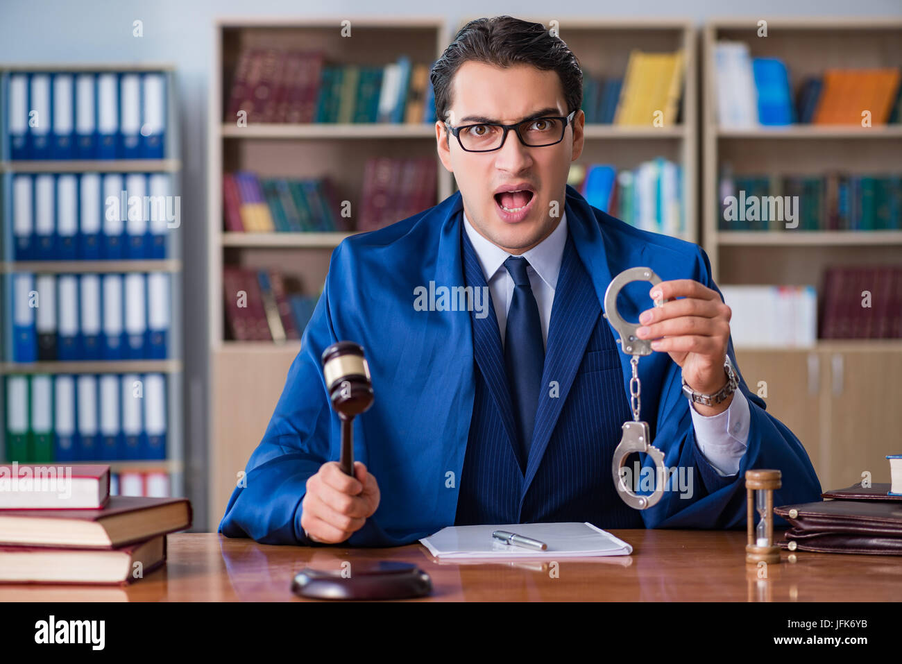 Handsome judge with gavel sitting in courtroom Stock Photo - Alamy