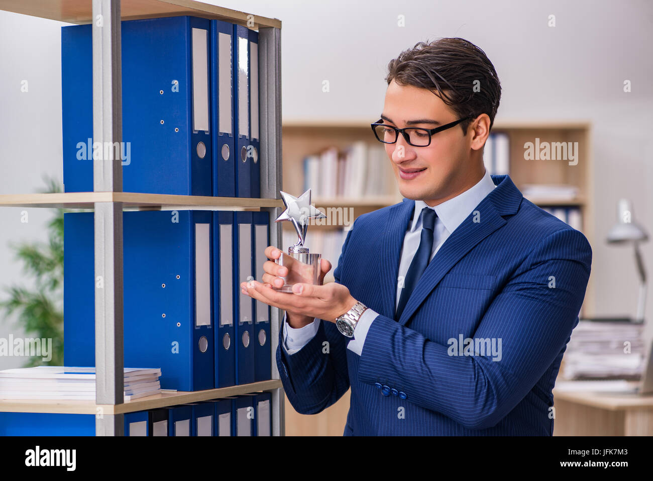 Young man standing next to the shelf with folders Stock Photo - Alamy