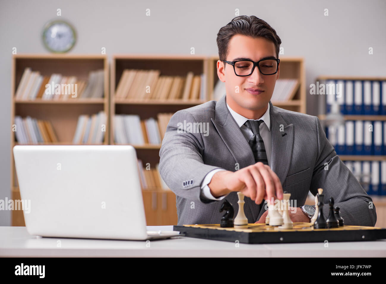 Young businessman playing chess in the office Stock Photo - Alamy
