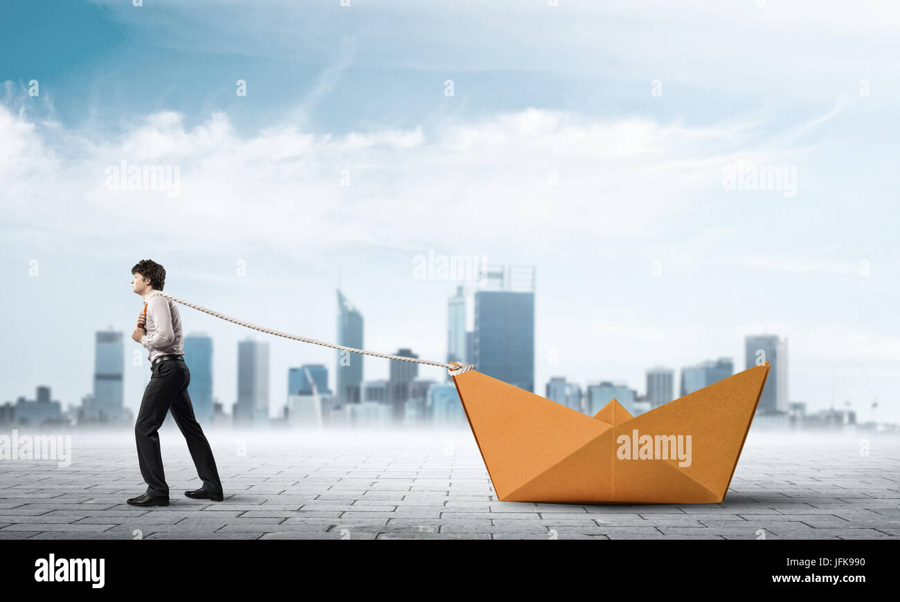 Successful businessman pulling with rope paper boat Stock Photo - Alamy