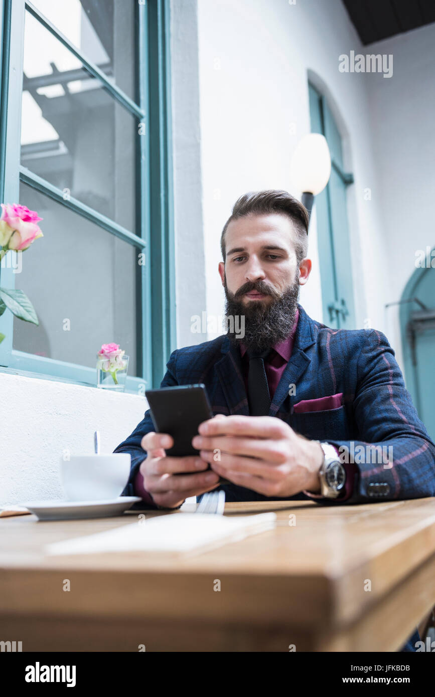 Young man using cell phone at cafe Stock Photo - Alamy