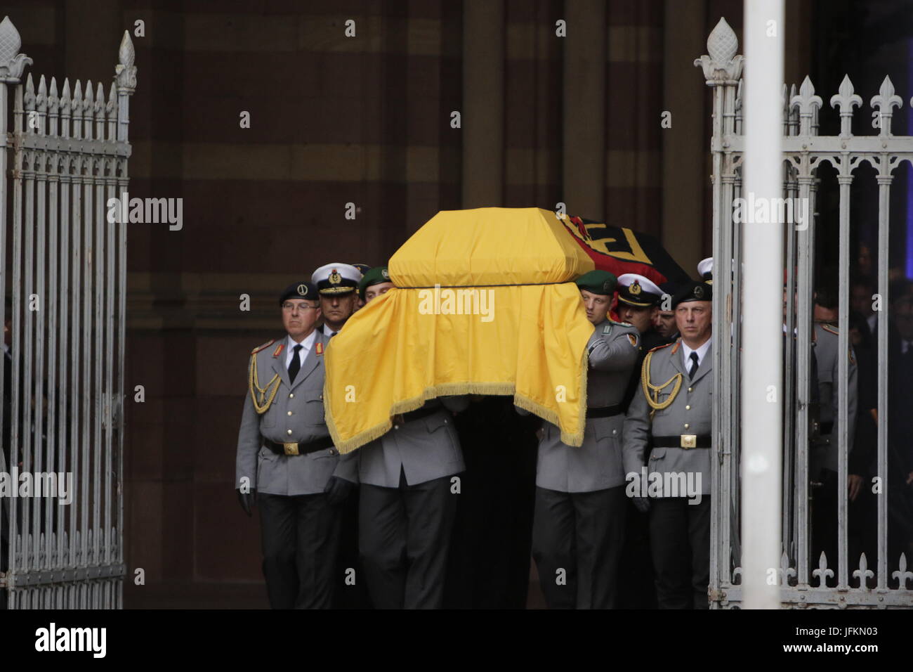 The coffin of Helmut Kohl, covered in a German flag is carried out of ...