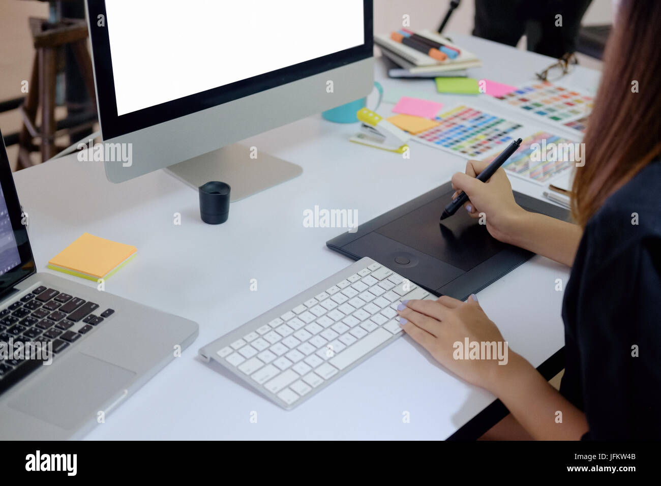 Young photographer and graphic designer at work in office. Blank screen ...