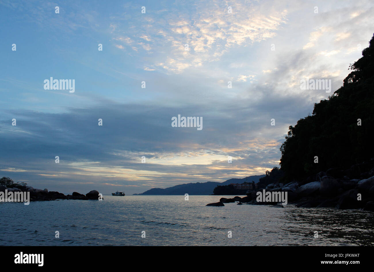 View of dawn at the seaside with the dramatic sky, boat and mountain ...