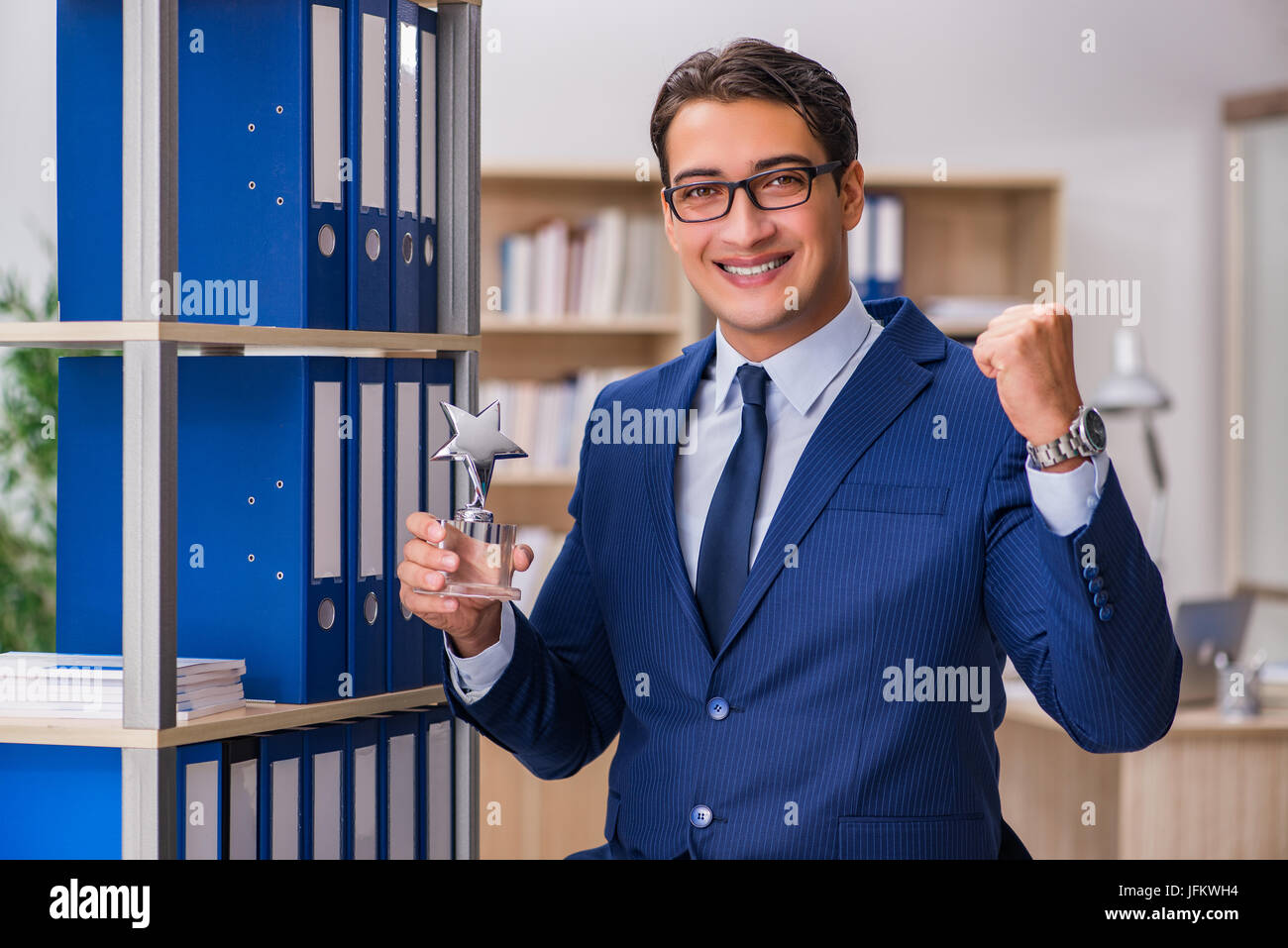 Young man standing next to the shelf with folders Stock Photo - Alamy