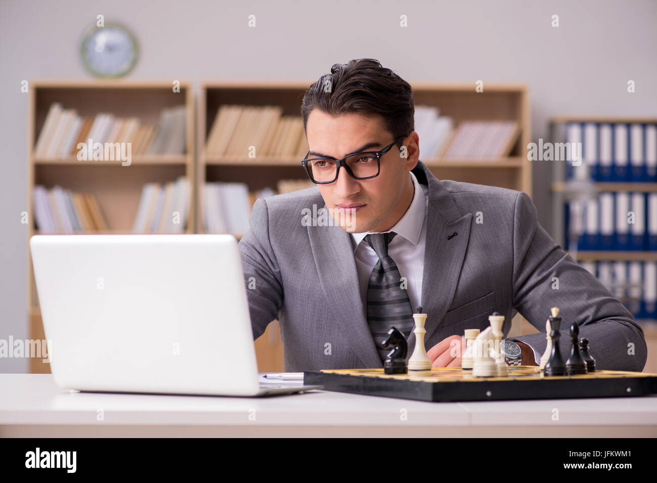 Young businessman playing chess in the office Stock Photo - Alamy