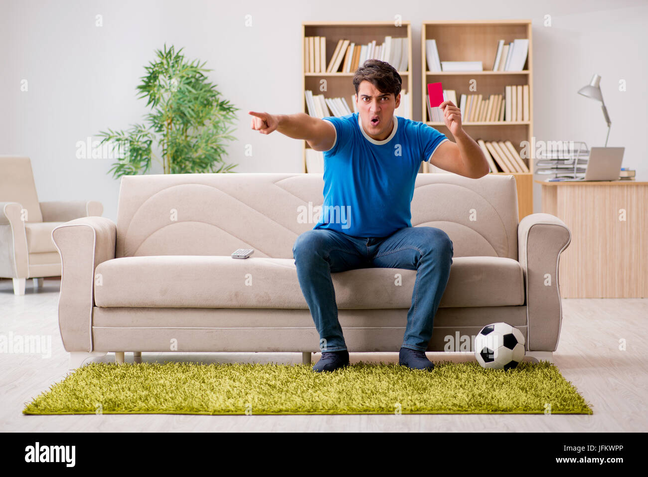 Man watching football at home sitting in couch Stock Photo - Alamy