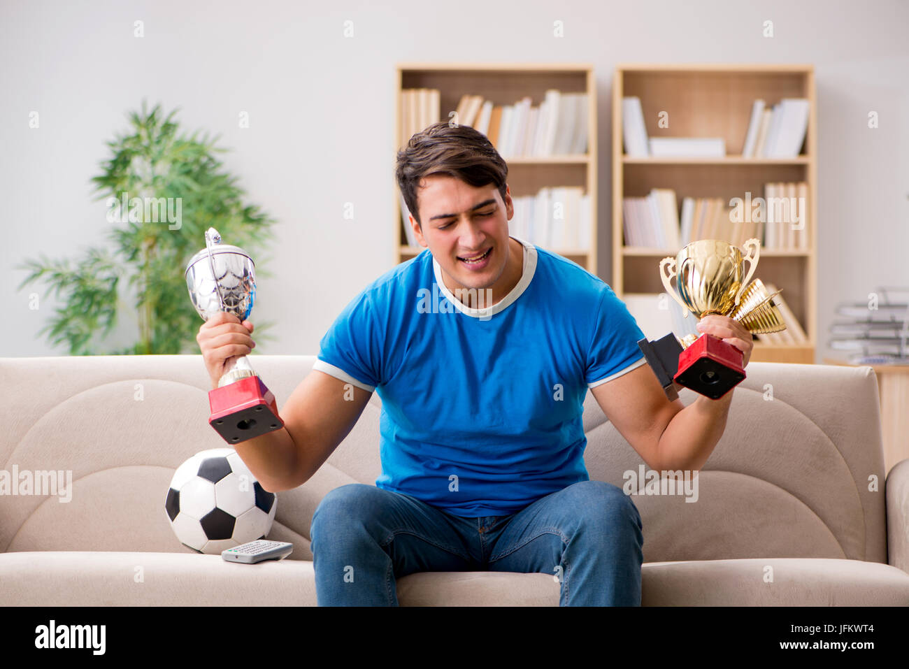 Man watching football at home sitting in couch Stock Photo - Alamy