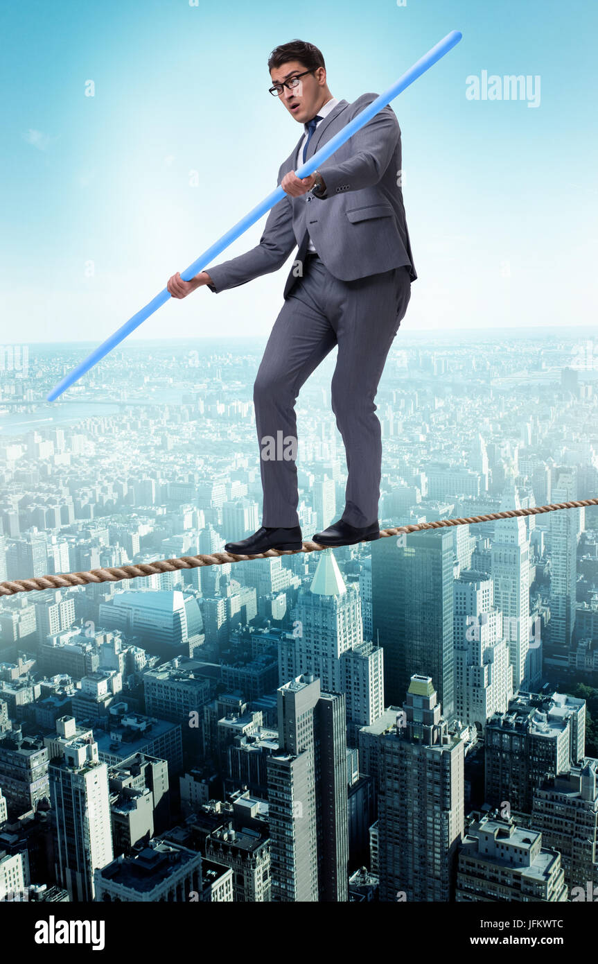 Businessman doing tightrope walking in risk concept Stock Photo - Alamy