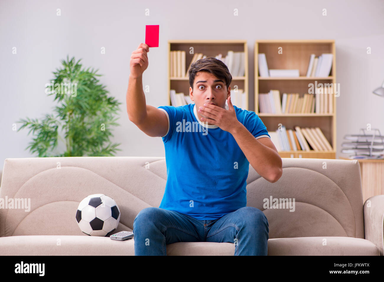 Man watching football at home sitting in couch Stock Photo - Alamy