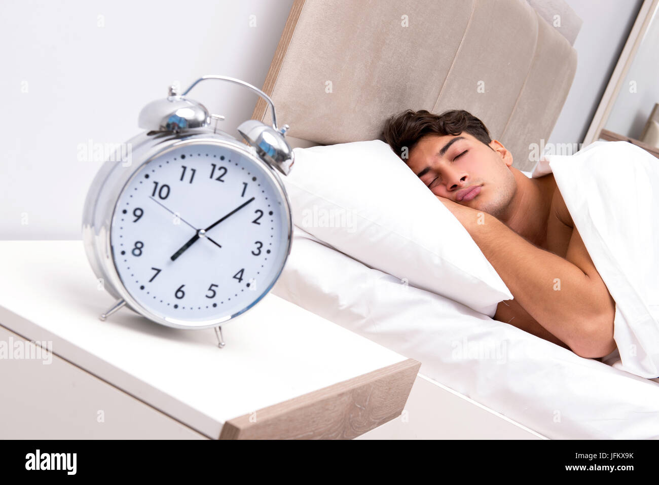 Young man having trouble waking up in the morning Stock Photo - Alamy