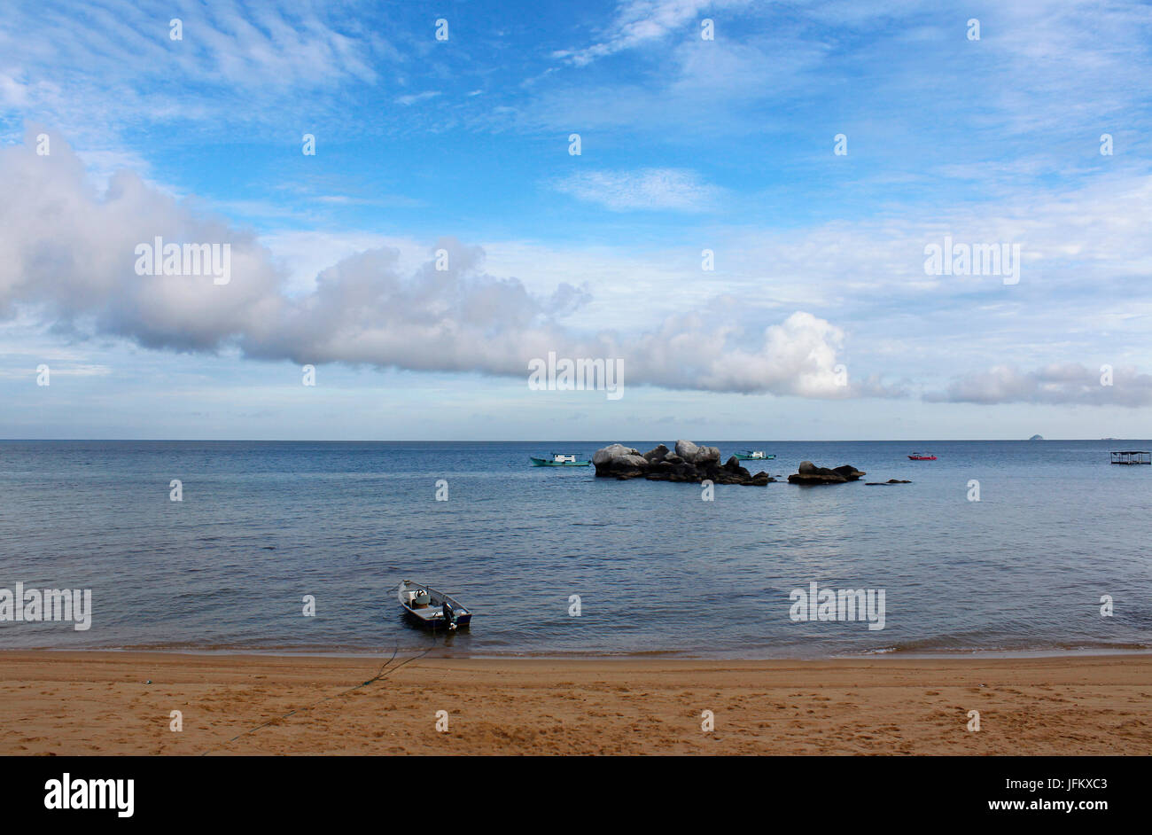 View of Tioman Island with the dramatic cloudscape, boats and rocks in ...