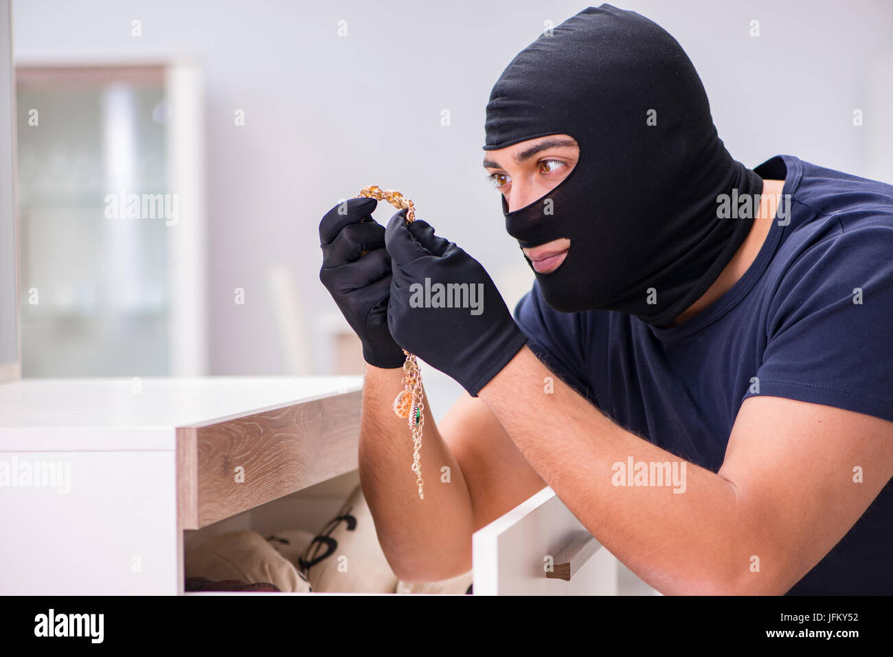 Robber wearing balaclava stealing valuable things Stock Photo - Alamy