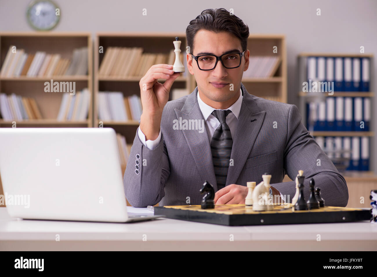 Young businessman playing chess in the office Stock Photo - Alamy