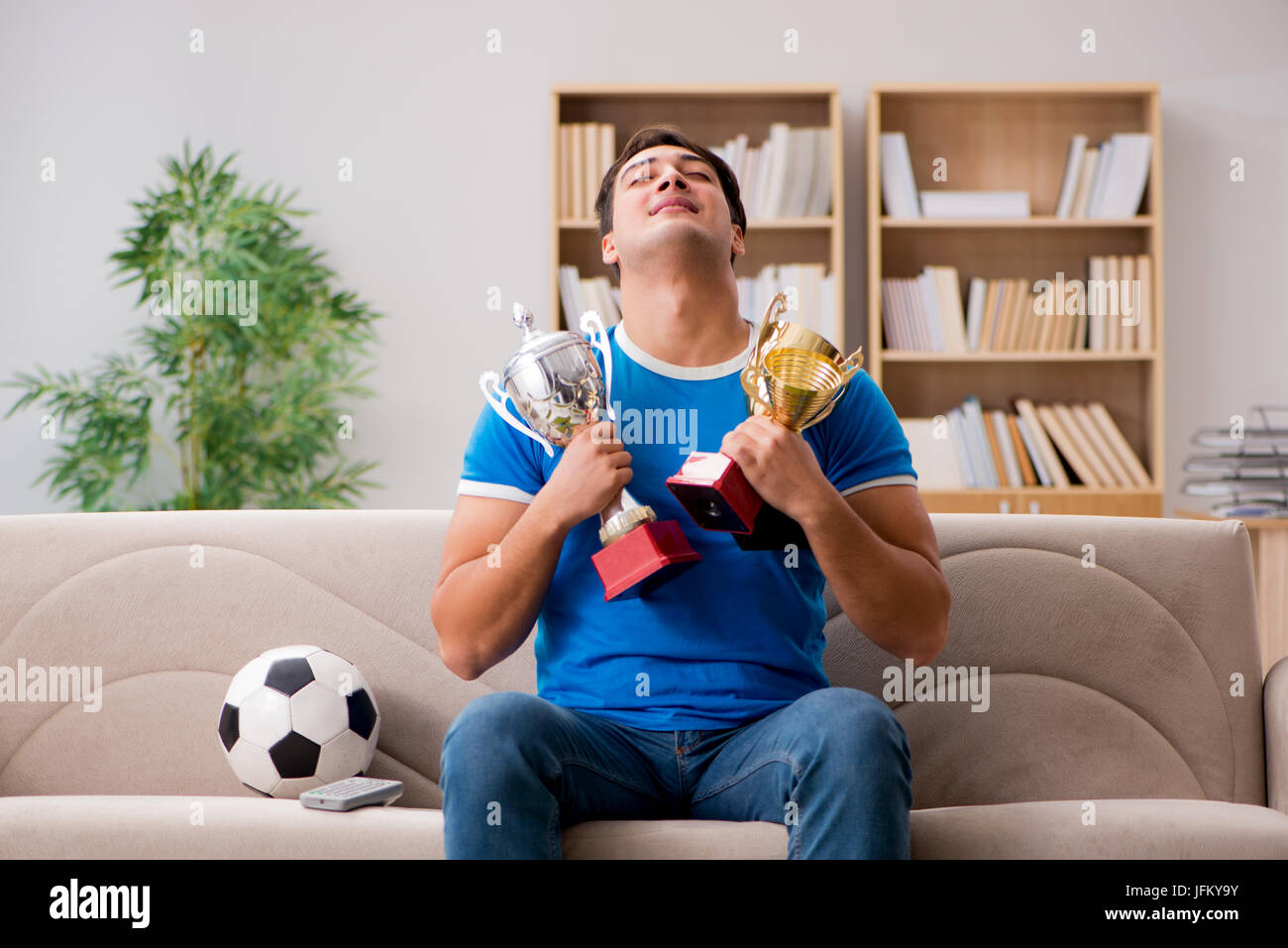 Man watching football at home sitting in couch Stock Photo - Alamy