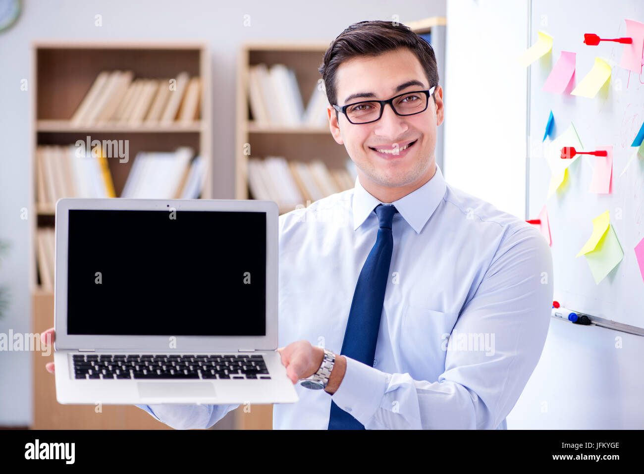 Young businessman demonstrating the screen of his laptop Stock Photo ...
