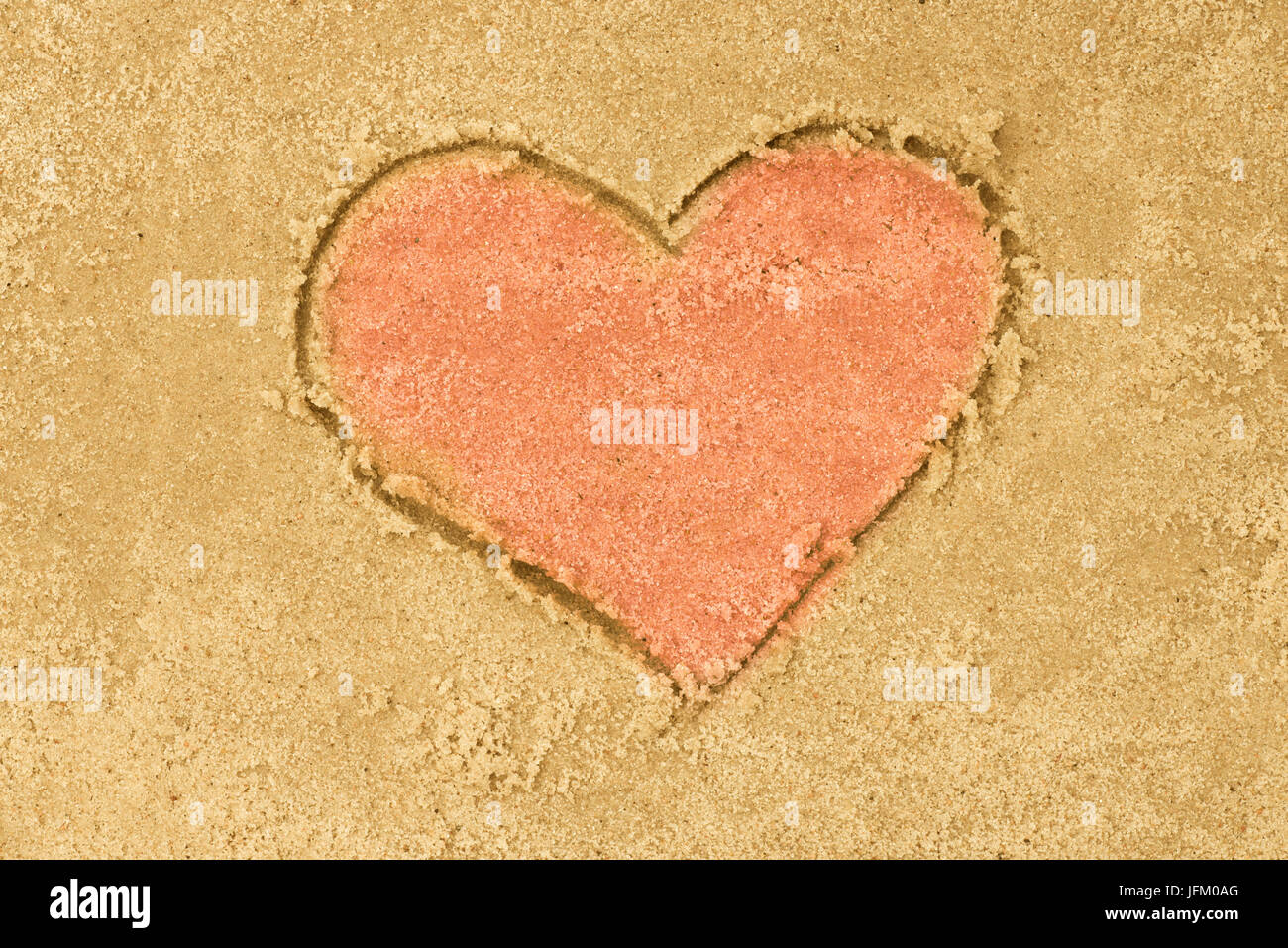 heatr shape drawing in sand background Stock Photo - Alamy
